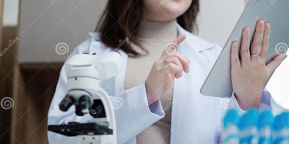 Scientist Using Tablet in Laboratory with Microscope for Research and ...