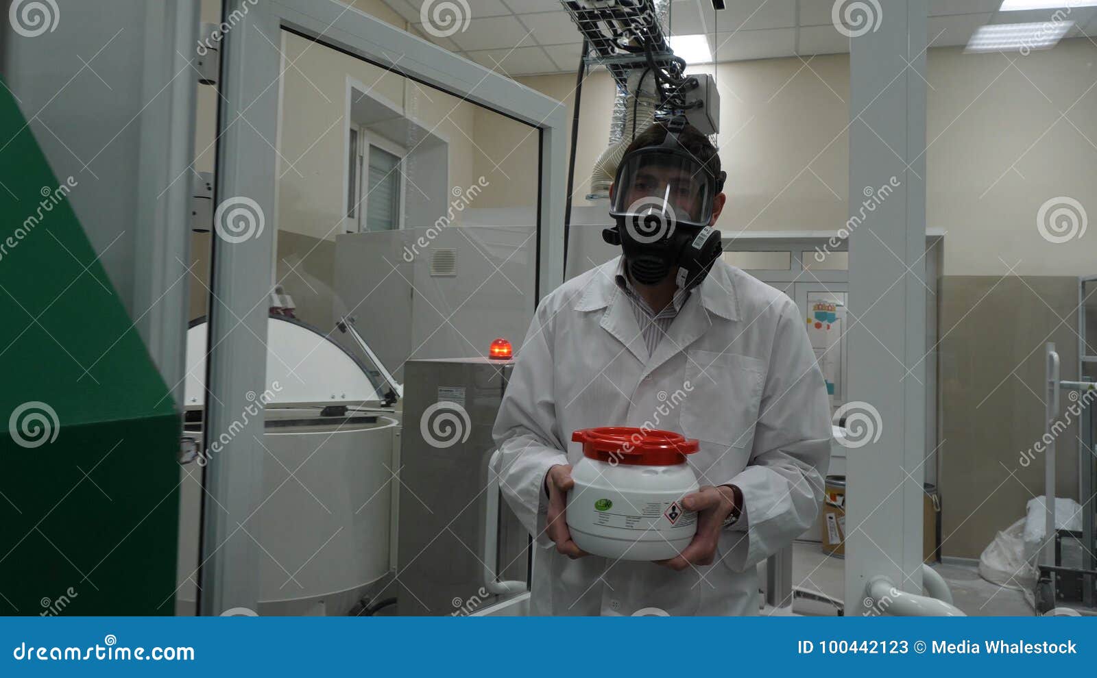 Scientist Wearing Protective Suit and Carrying a Jar of Toxic Liquid ...