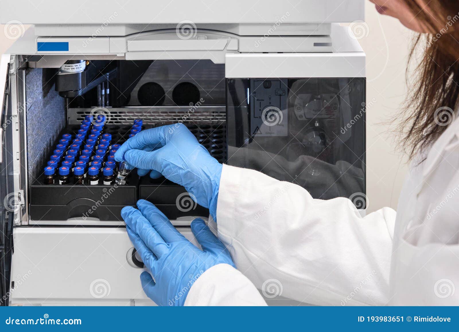 Scientist In A White Lab Coat Putting Vial With A Sample Into ...
