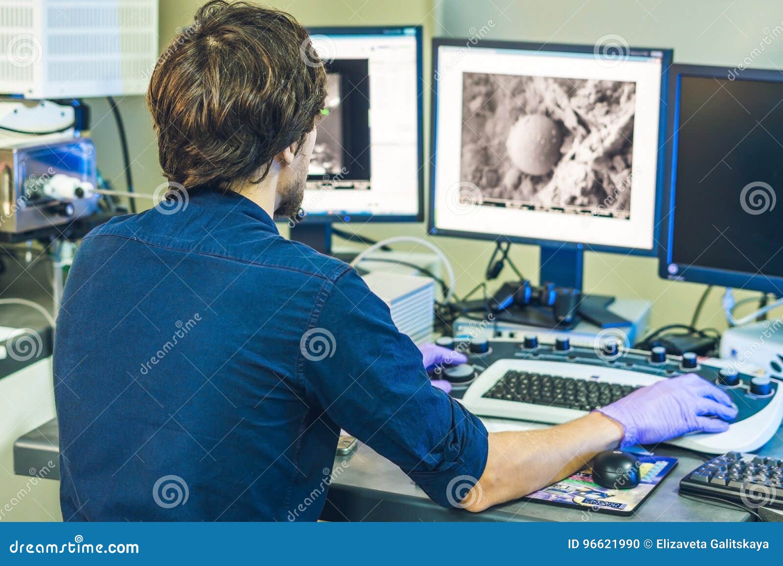 Scientist Works at a Electron Microscope Control Pannel with Two Stock ...