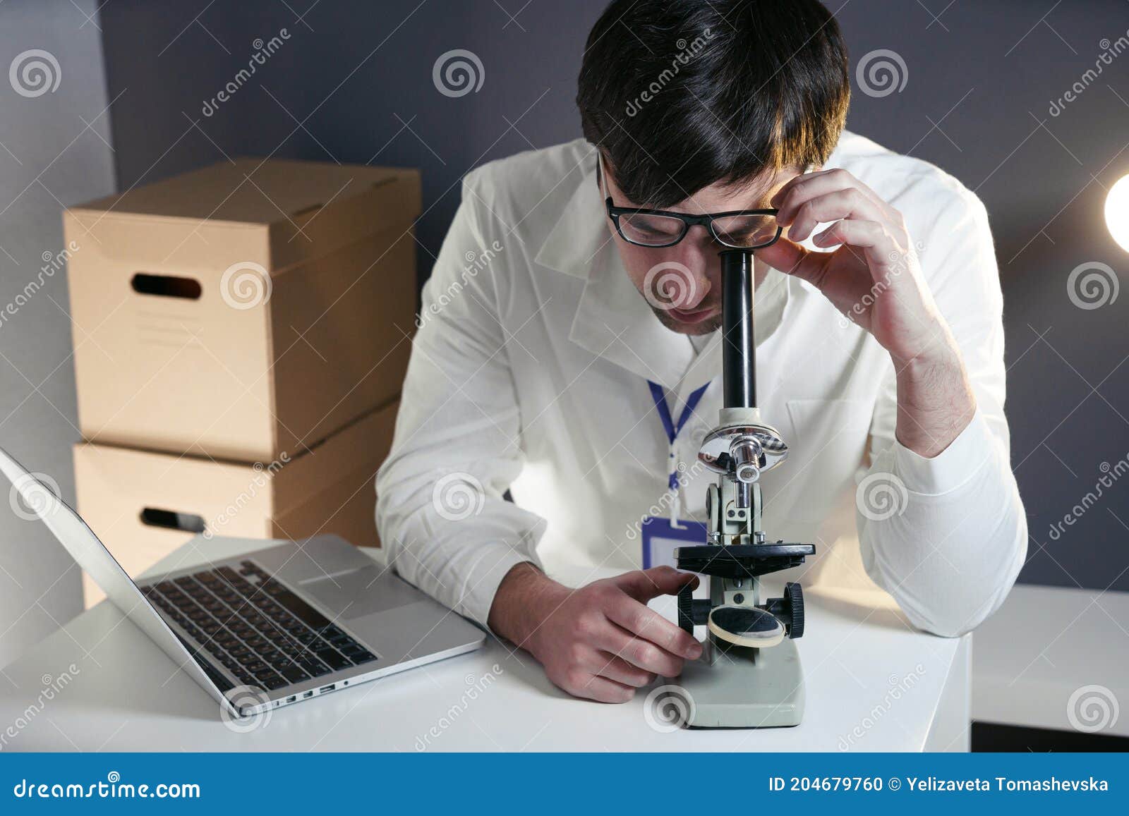 Scientist at Workspace in Laboratory with Microscope, Computer, and ...