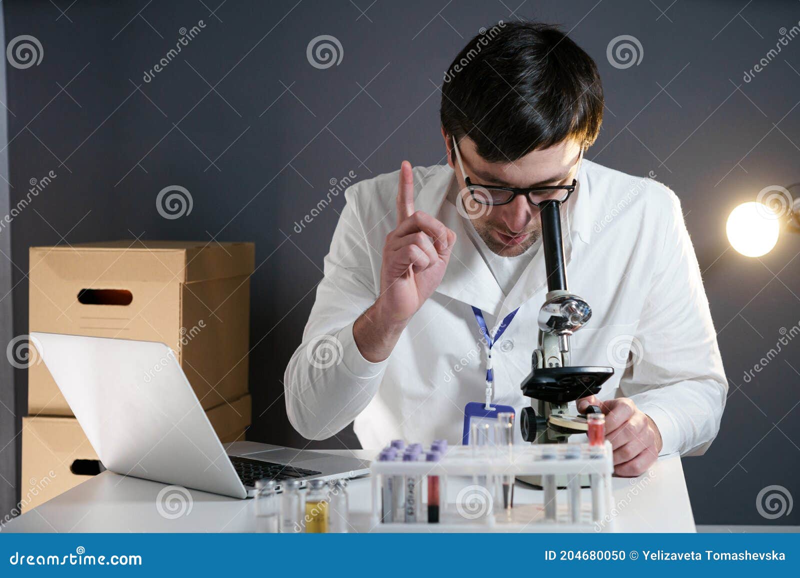 Scientist at Workspace in Laboratory with Microscope, Computer, and ...
