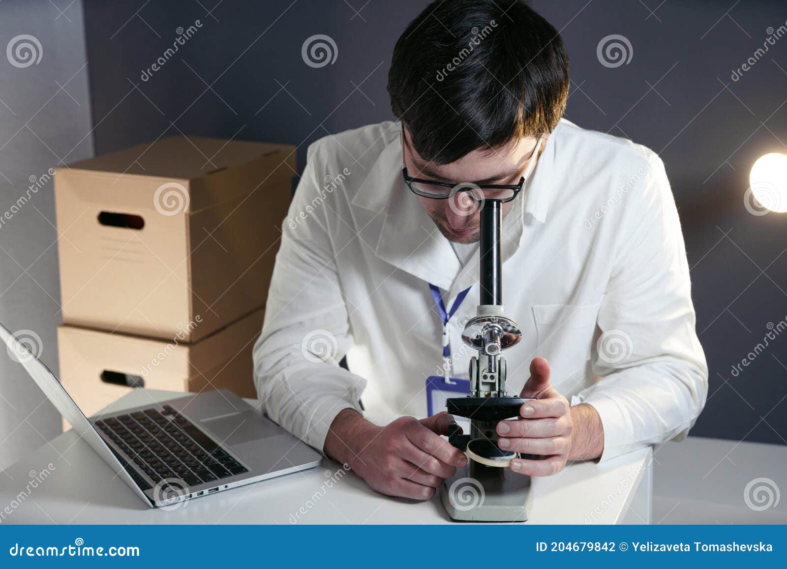 Scientist at Workspace in Laboratory with Microscope, Computer, and ...