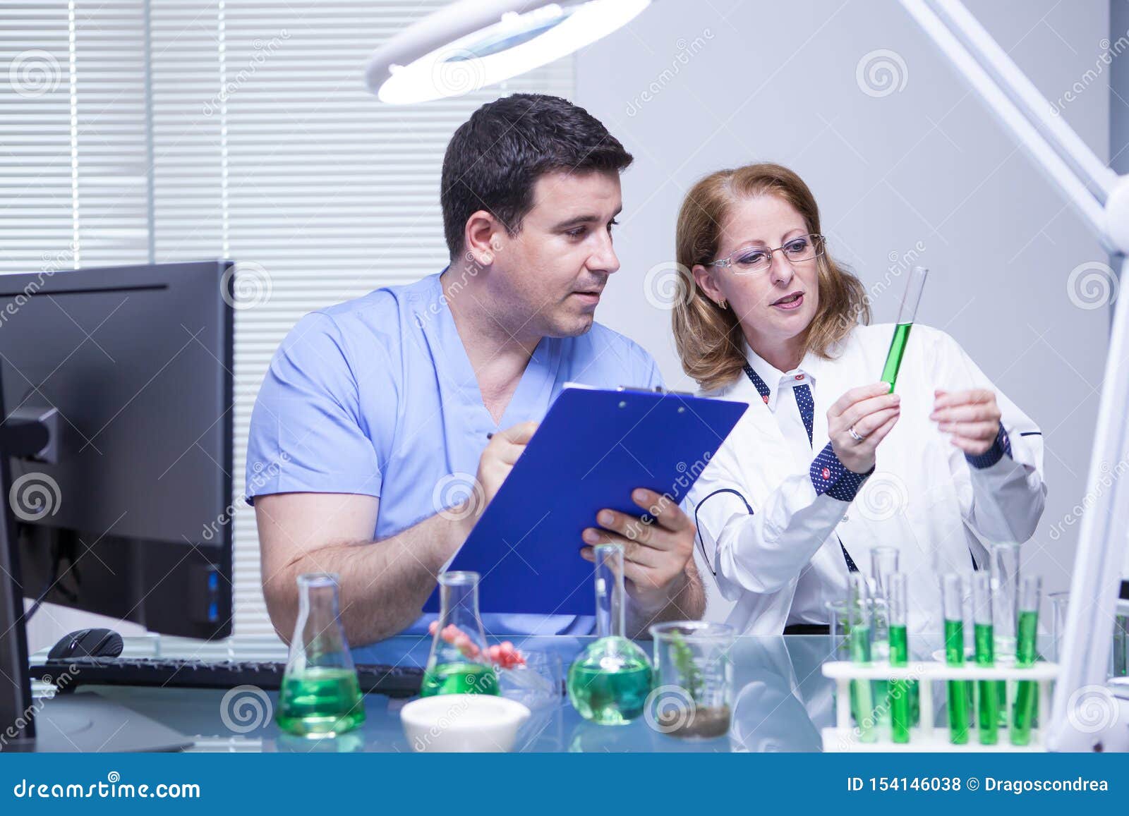Scientists in Biotechnology Checking the Solution from a Test Tube ...