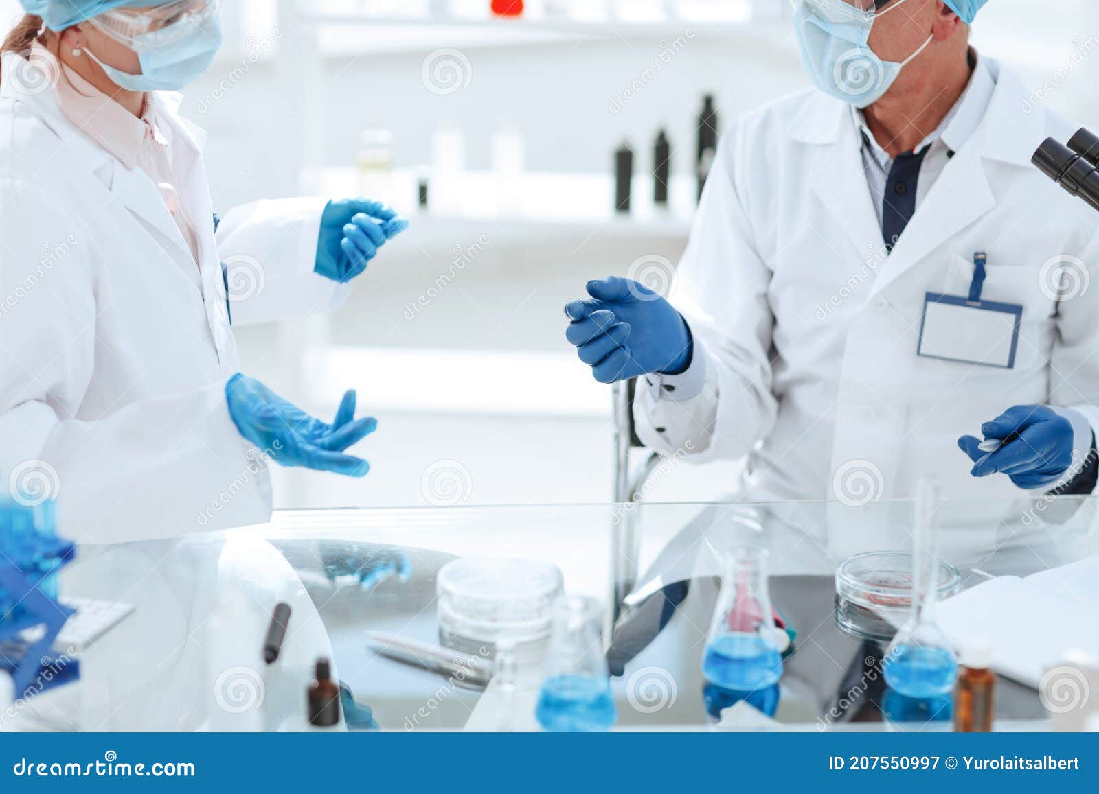 Scientists Colleagues Checking The Liquid In Laboratory Flasks. Royalty ...