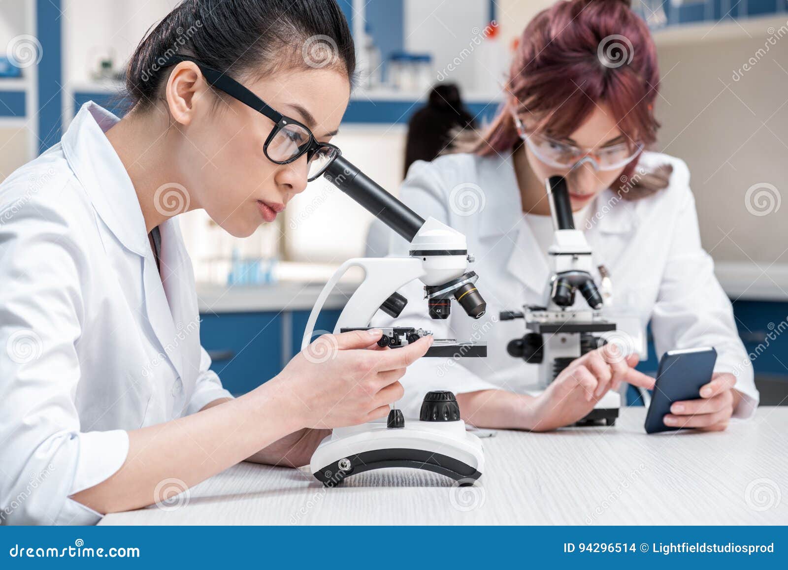 Scientists Group Working with Microscopes and Smartphone in Chemical ...