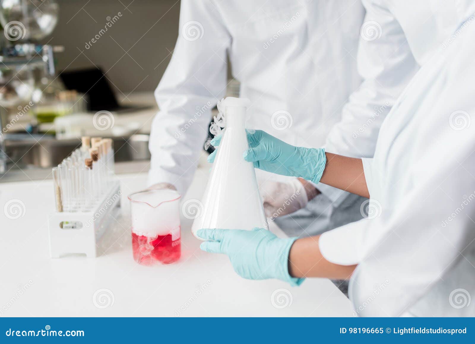 Scientists Making Experiment with Reagent and Flasks Stock Image ...