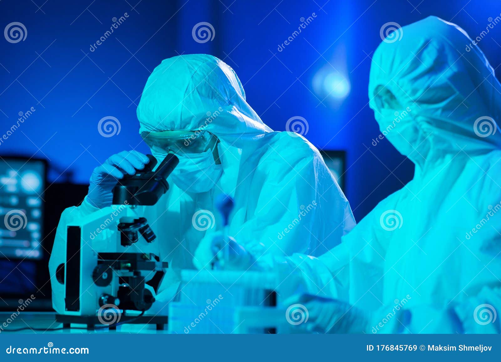 Scientists in Protection Suits and Masks Working in Research Lab Using ...