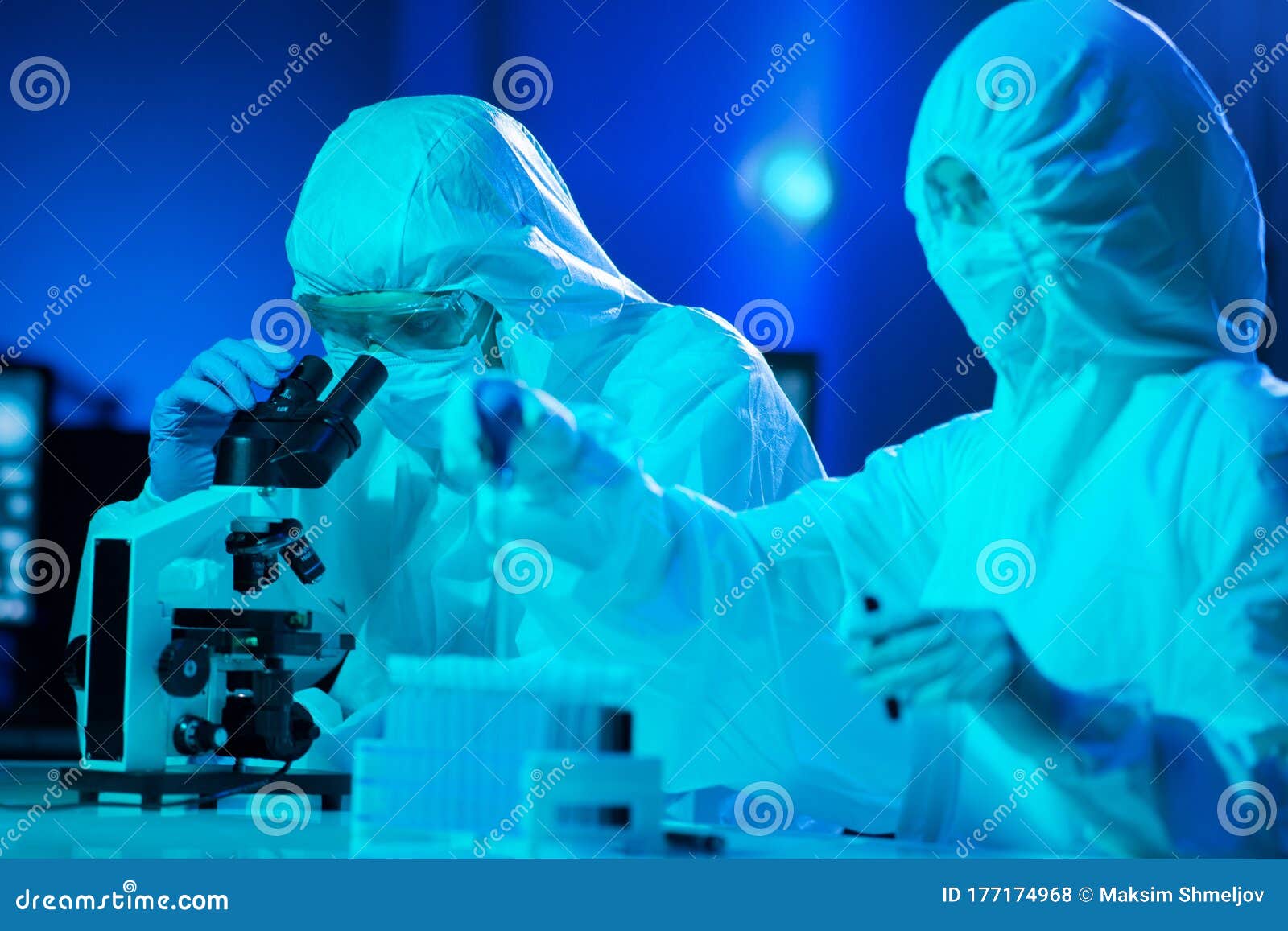 Scientists in Protection Suits and Masks Working in Research Lab Using ...