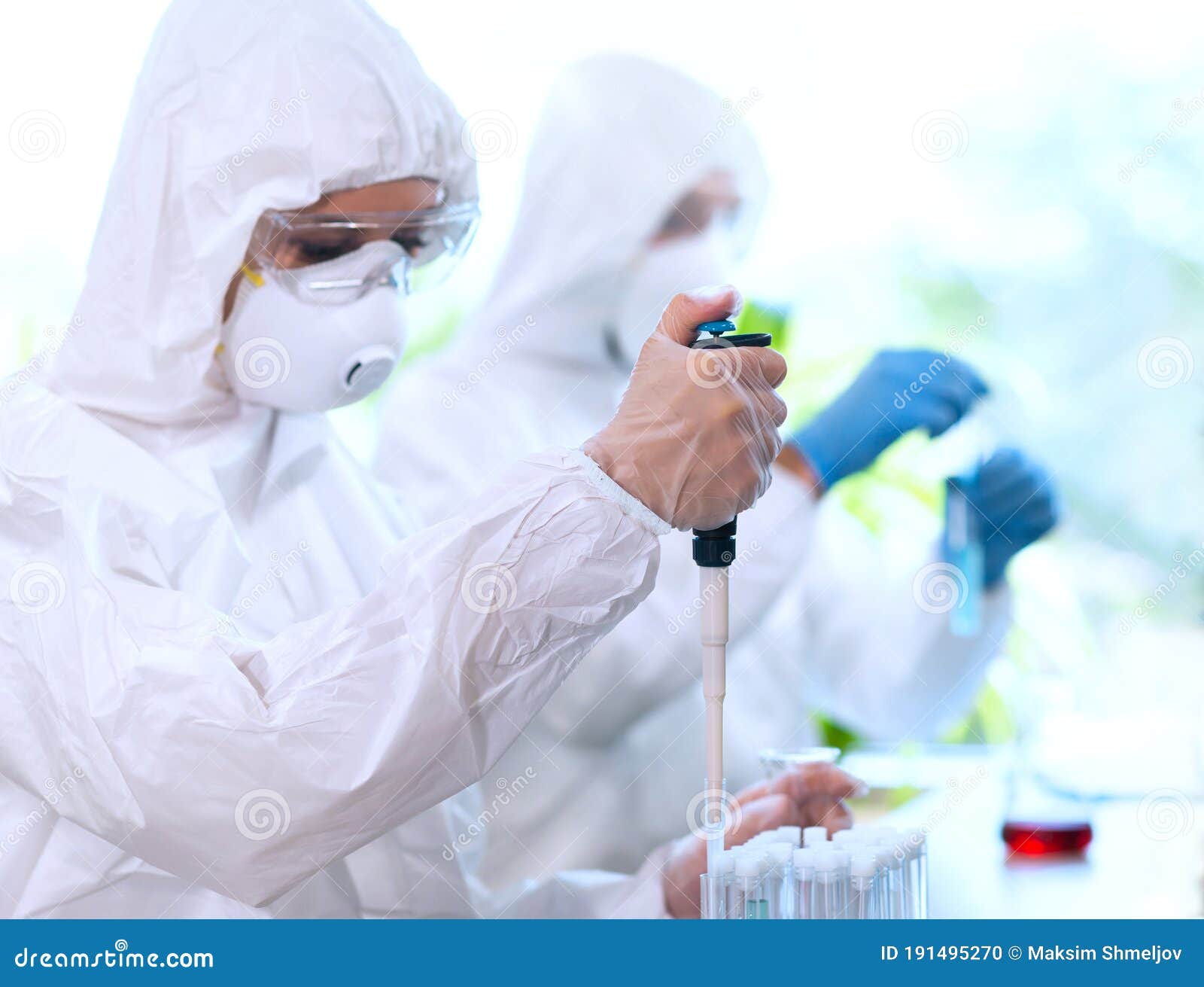 Scientists in Protection Suits and Masks Working in Research Lab Using ...