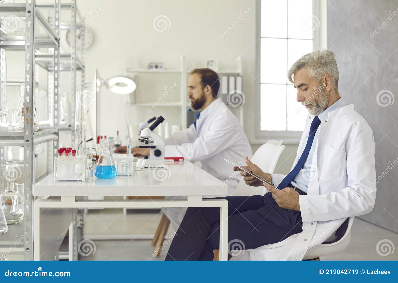 Serious Scientists and Researchers Working Sitting at a Table in a ...