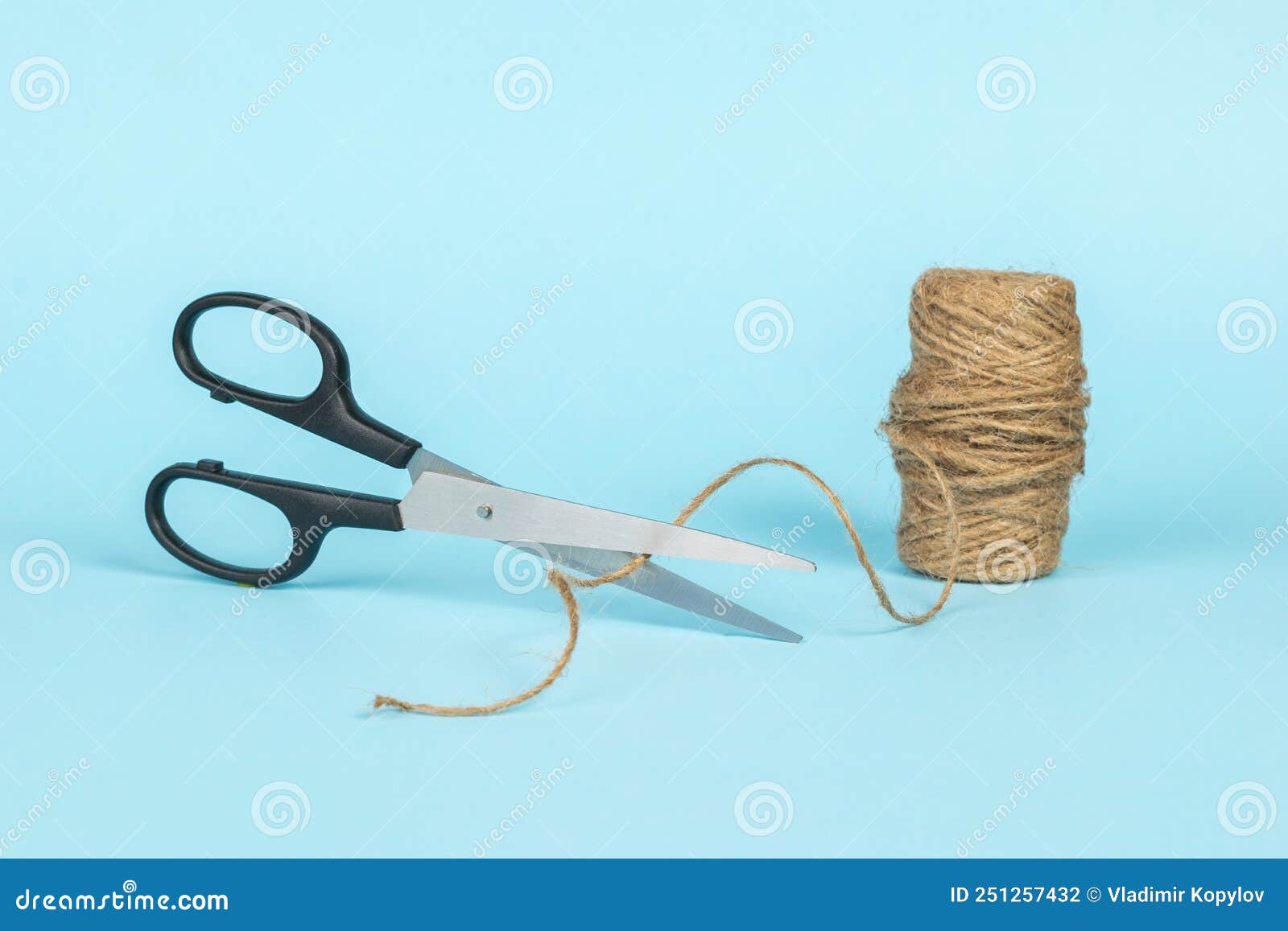 Scissors Cutting the Thread from the Coil on a Blue Background Stock ...