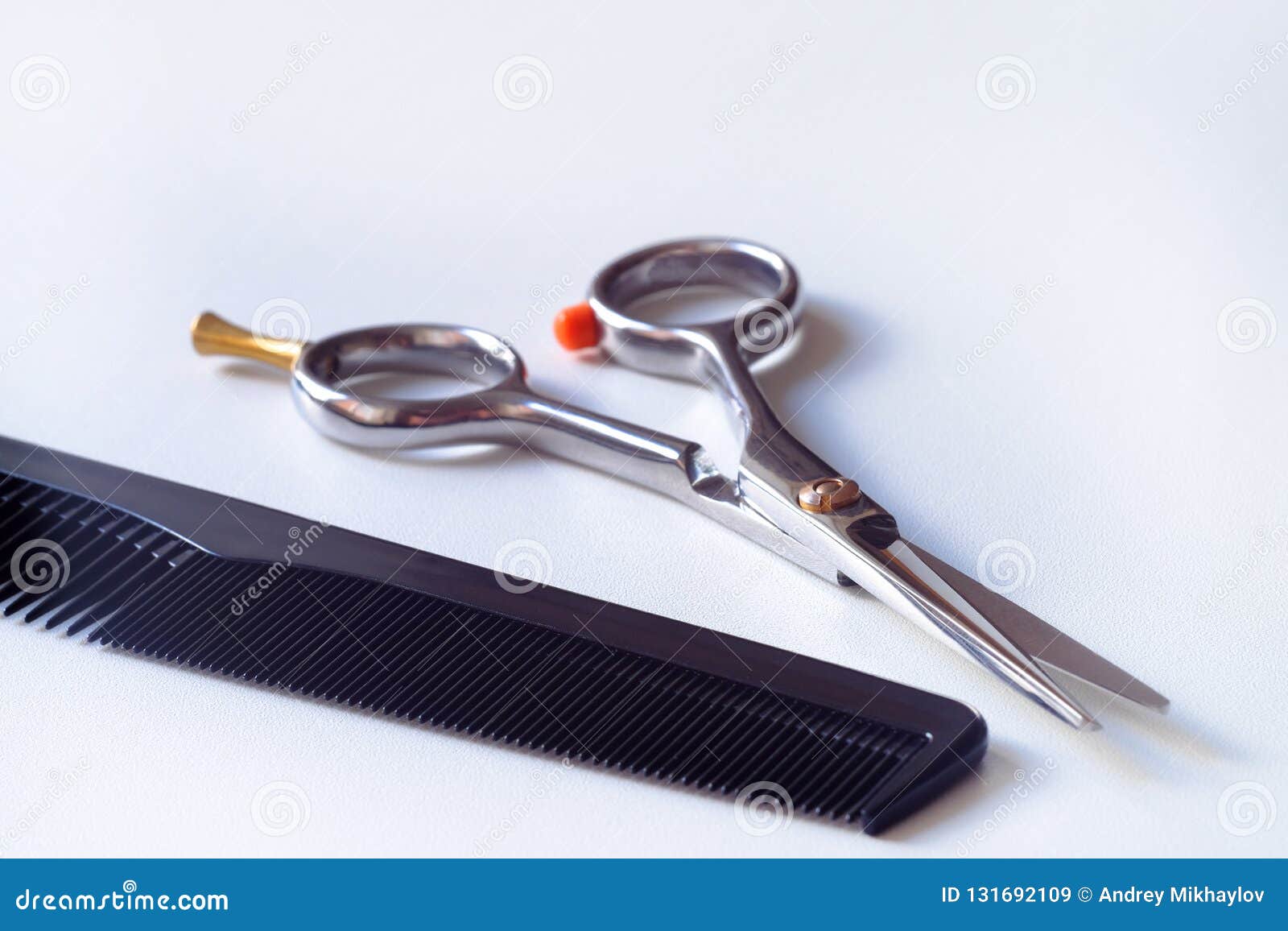 Scissors with Finger Rest on Ring and Comb on White Background Stock ...