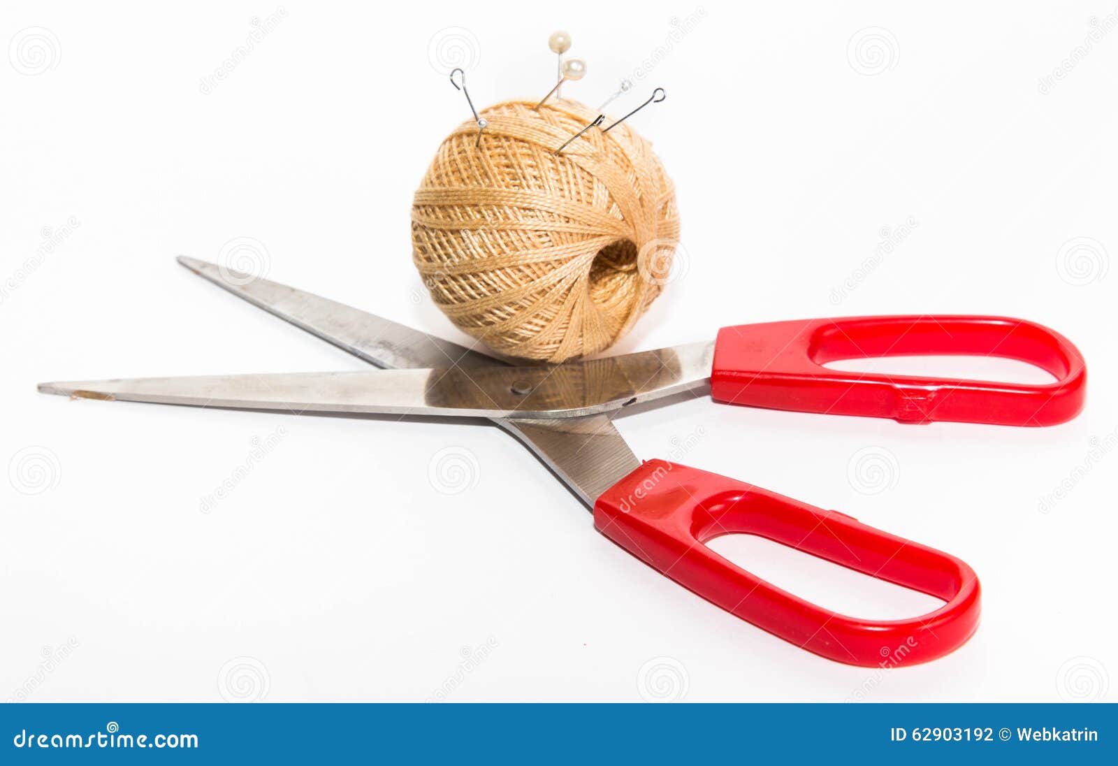 Scissors with Red Handles and a Ball of Beige Threads with Pins, on a ...
