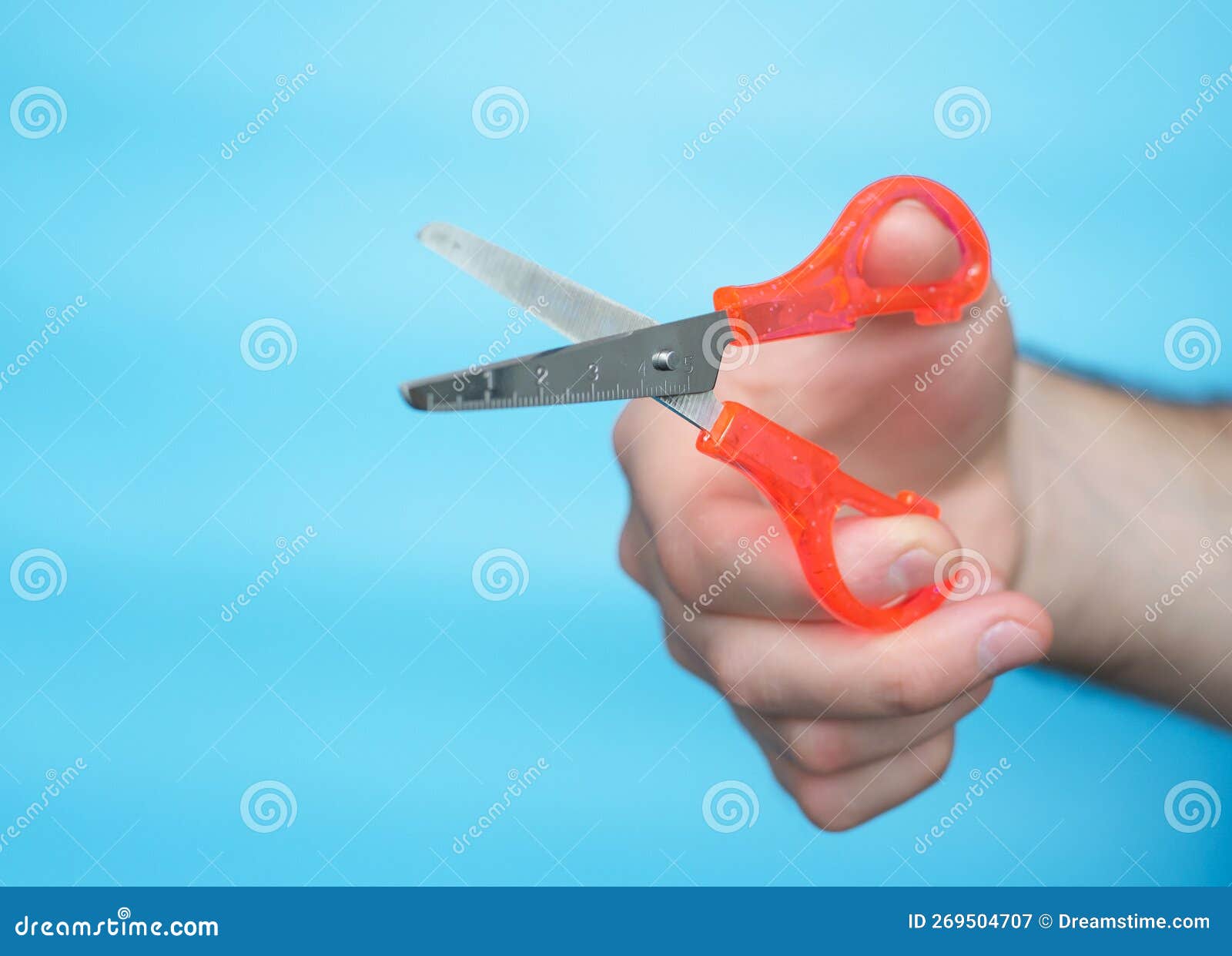 Scissors with a Ruler Scale in a Male Hand on a Blue Background, a ...