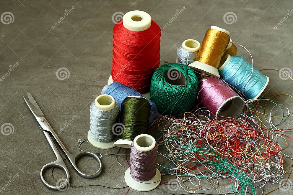Scissors, Tangled Colored Threads and Spools of Thread are on the ...