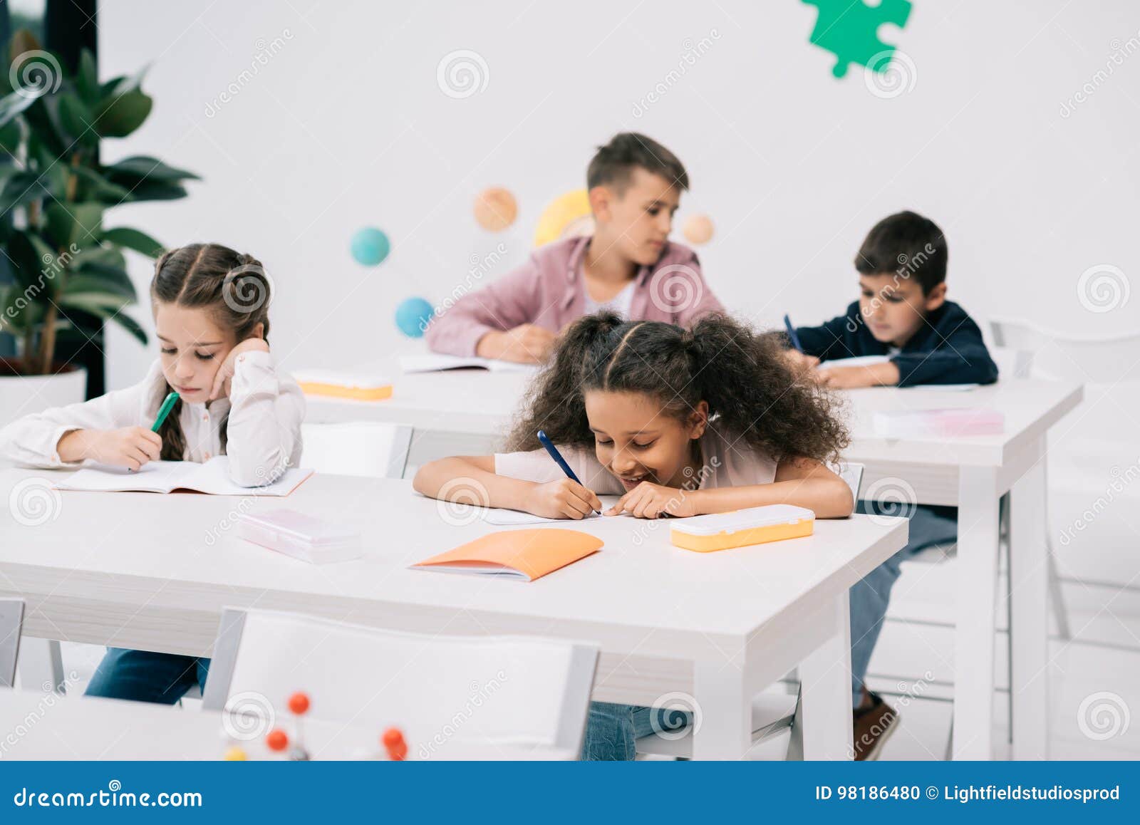 Scolari Che Scrivono in Quaderni E Che Studiano Insieme Nell'aula ...