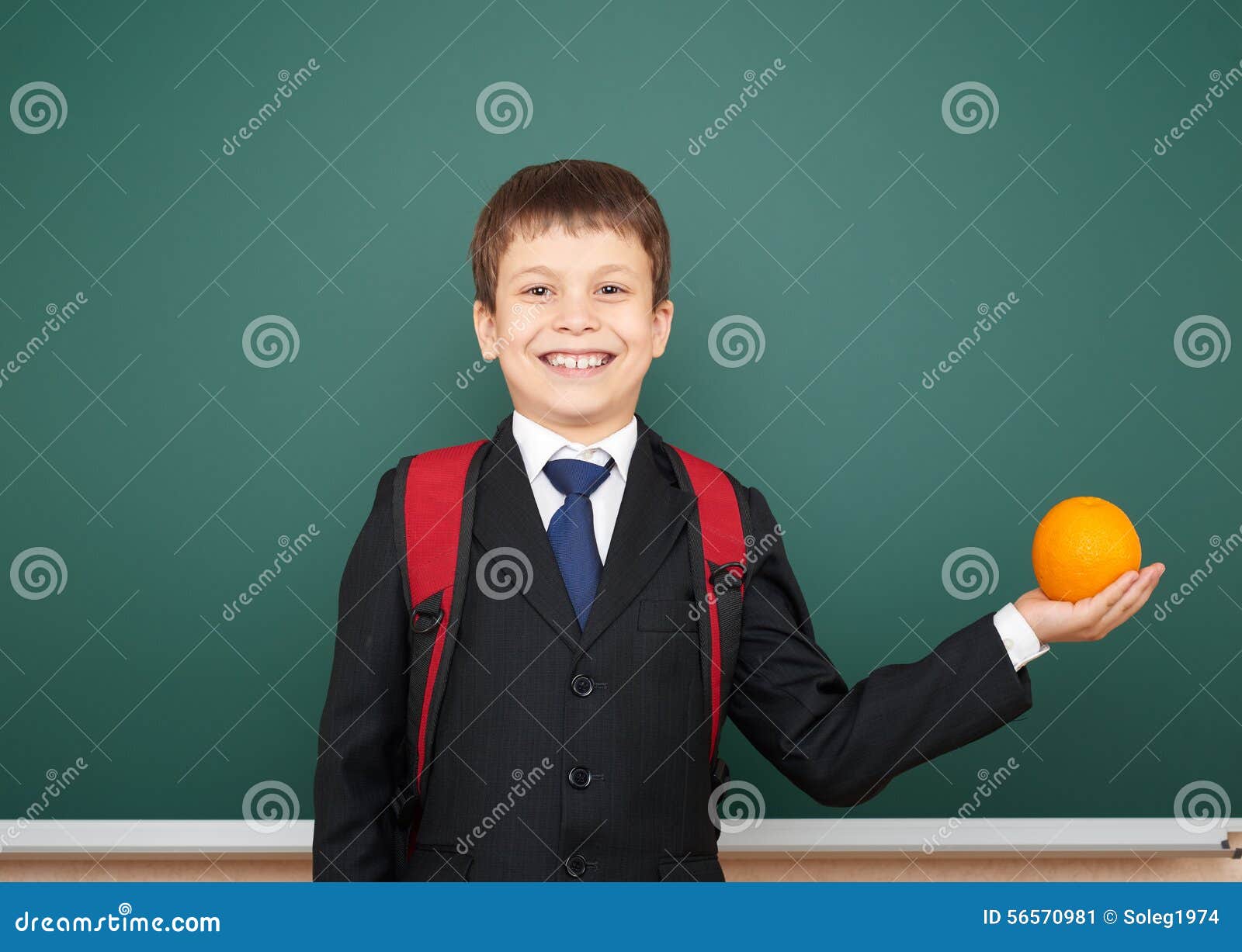 Scolaro Con L'arancia Ed Il Consiglio Scolastico Immagine Stock ...