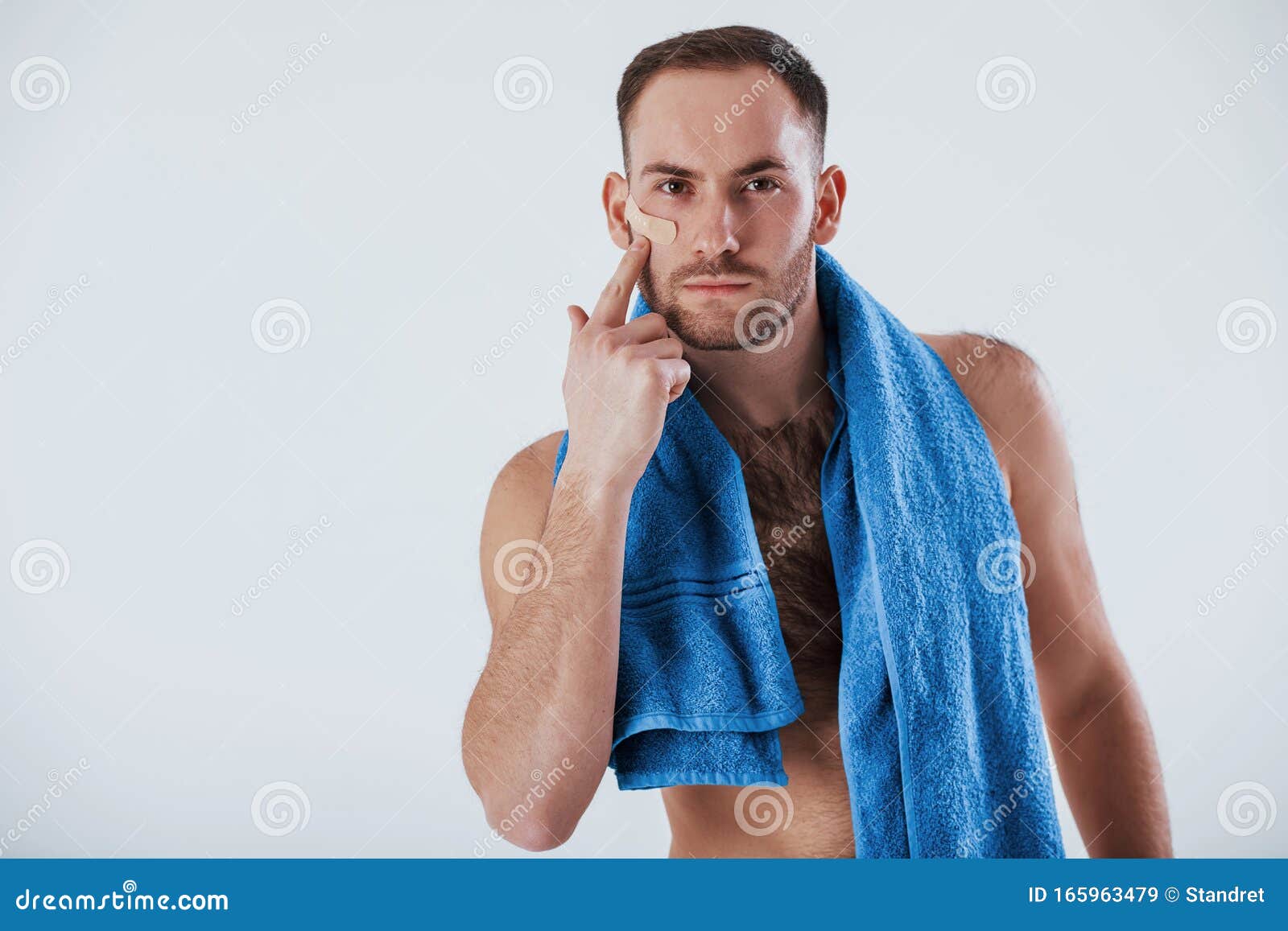 Scratch on Face. Man with Blue Towel Stands Against White Background in ...