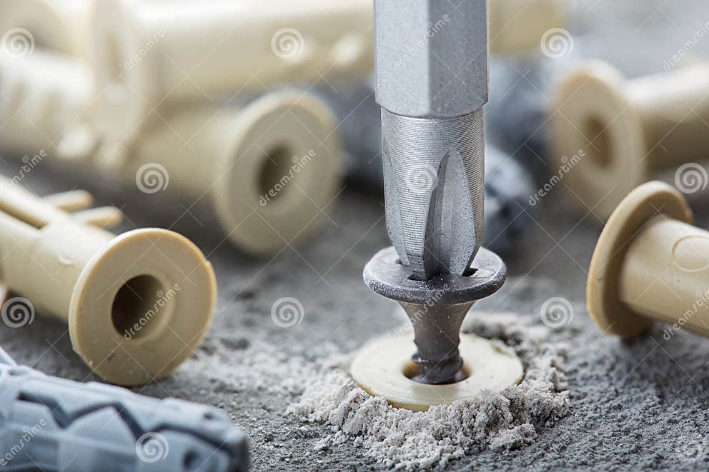 Screwdriver and Dowel in a Concrete Wall Background Stock Image - Image ...