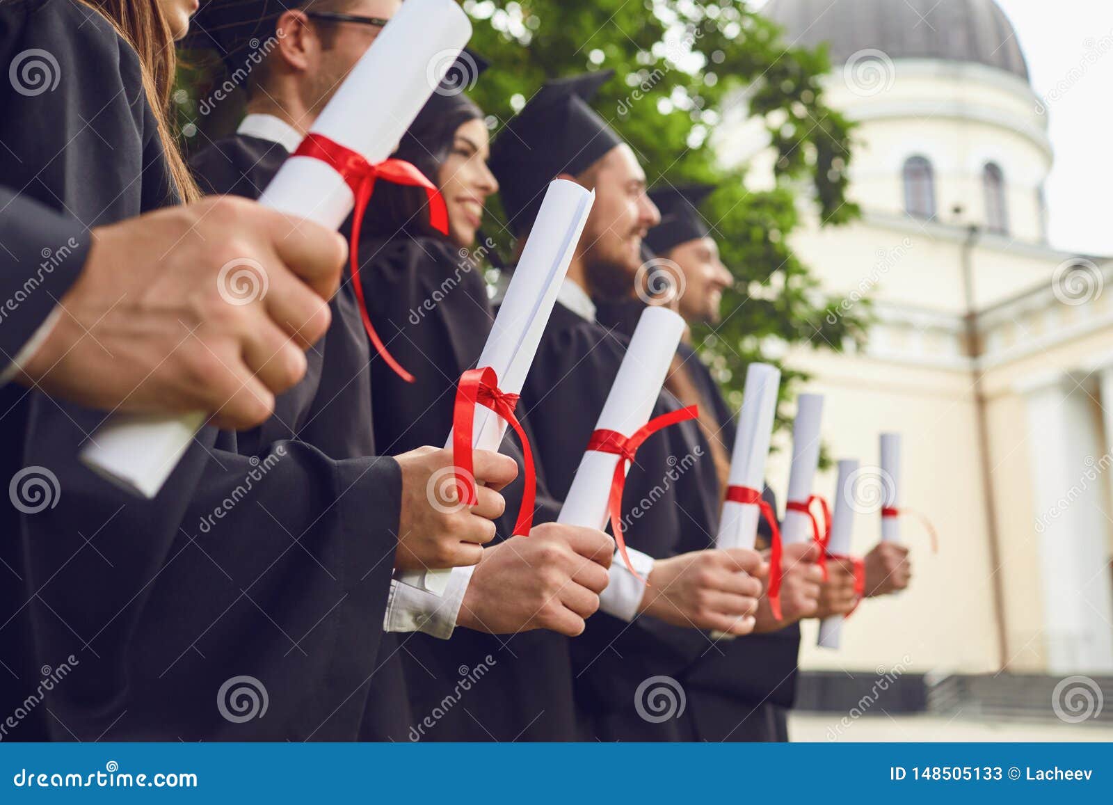 Scrolls of Diplomas in the Hands of a Group of Graduates. Stock Image ...