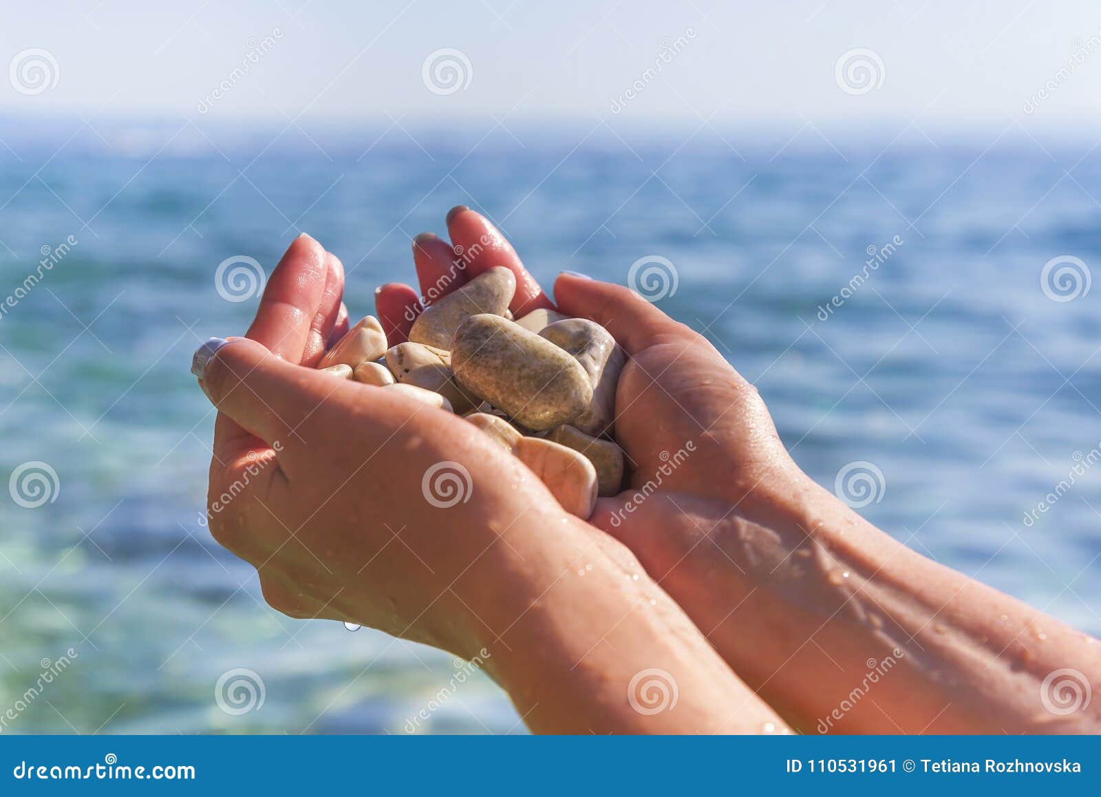 Sea pebbles in the hand. stock image. Image of beach - 110531961