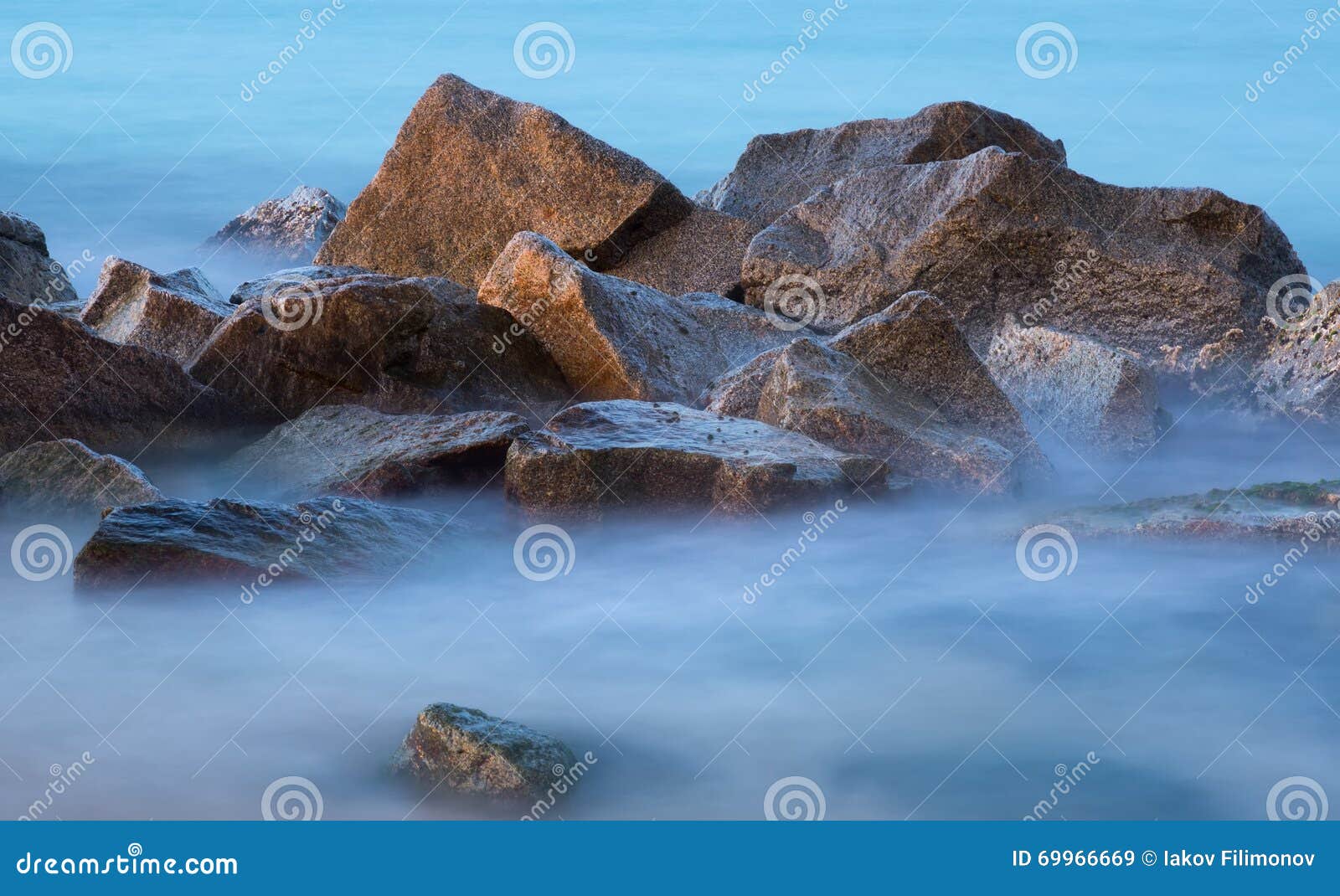 Sea rocks in mist at dusk stock image. Image of shore - 69966669