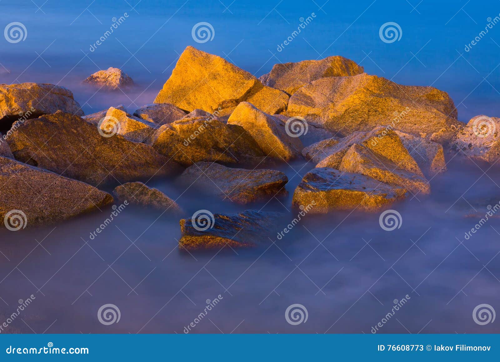 Sea rocks in mist at dusk stock image. Image of coat - 76608773