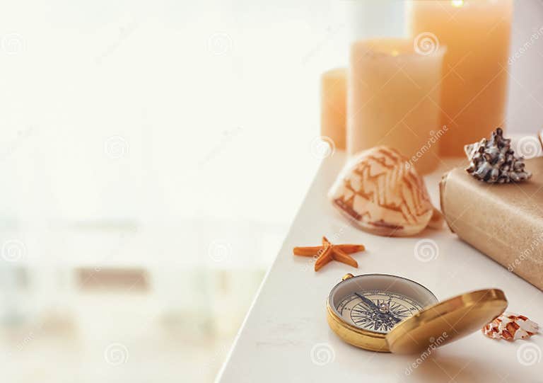 Sea Shells with Compass and Burning Candles on White Shelf Stock Photo ...