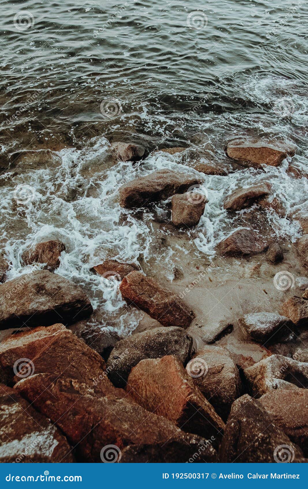 The Sea Water Splashing Against the Rocks in the Sand of the Beach ...