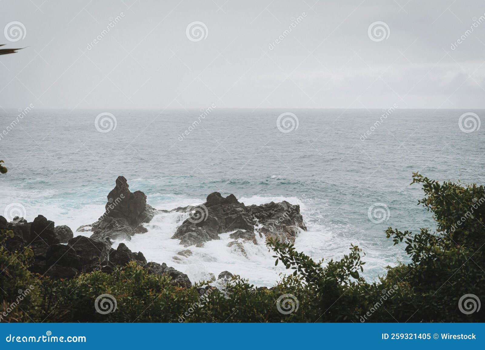 Sea Waves Splash Over the Rocks on the Shore with a Gray Sky in the ...
