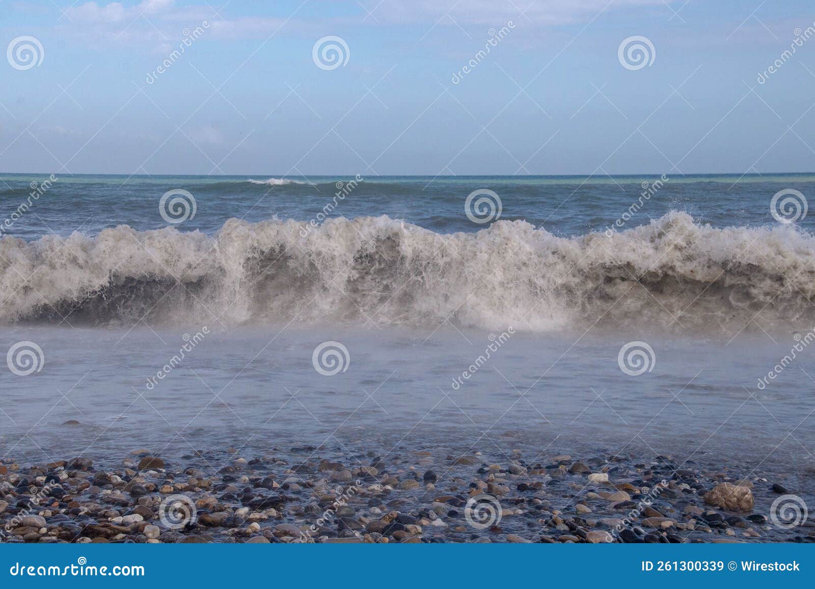 Sea Waves Splashing Over the Shore with a Cloudy Blue Sky in the ...