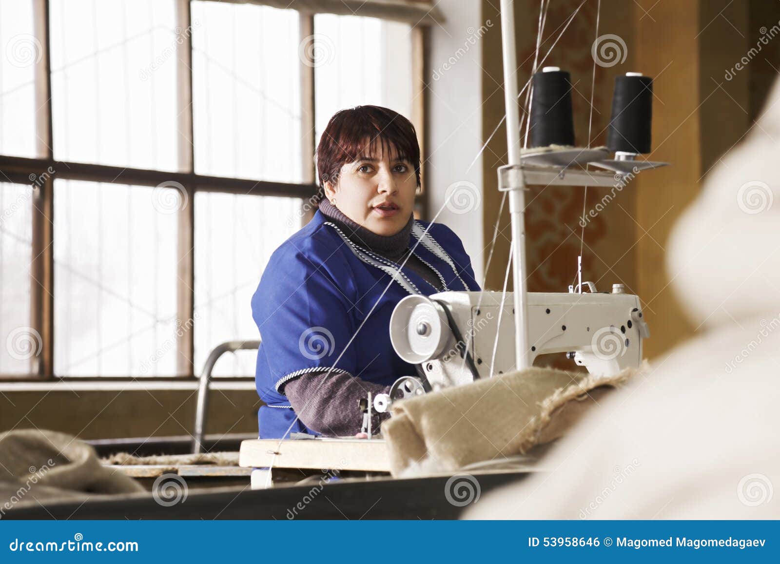 Seamstress in blue smock stock photo. Image of person - 53958646