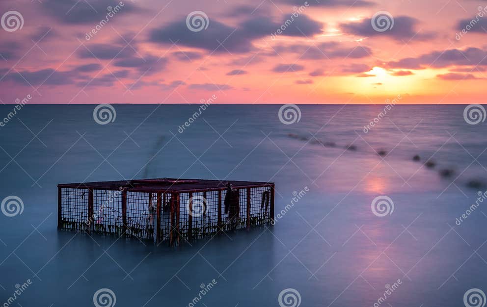 Seascape and Empty Cage at Colorful Sunset Stock Image - Image of ...