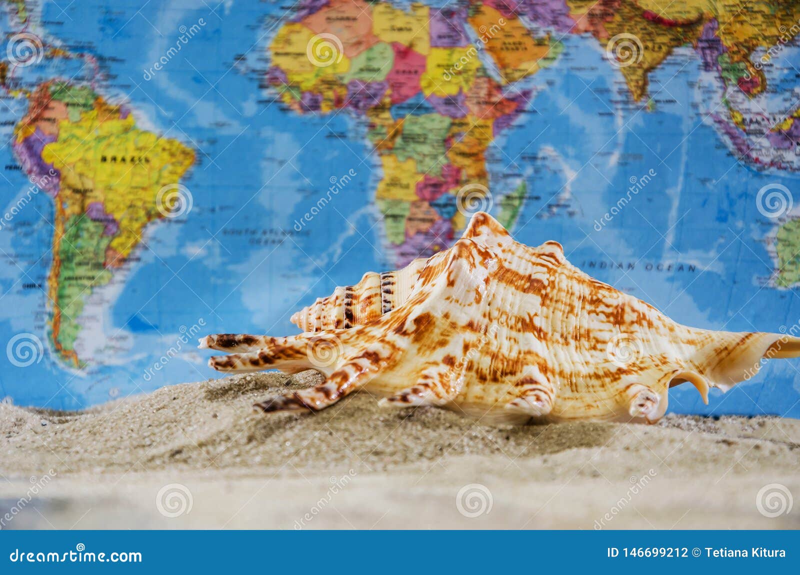 Seashell in the Sand on a Background of the World Map Stock Photo ...