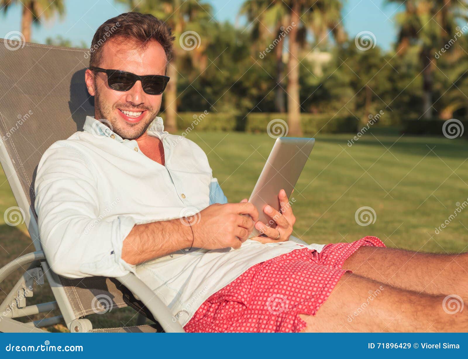 Seated Man in Sunglasses Holding a Tablet Pad Computer Stock Image ...