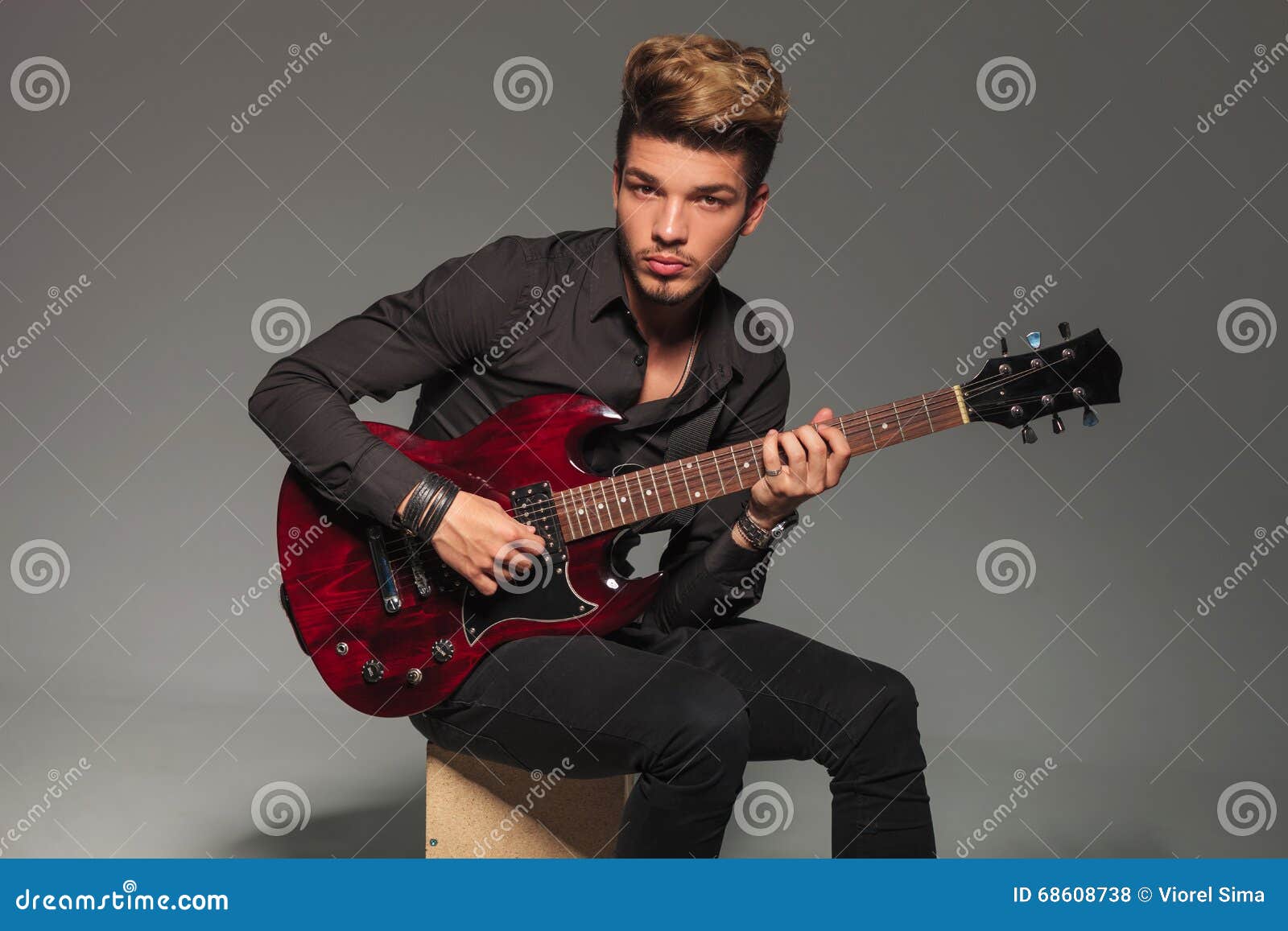 Seated Young Man Playing an Electric Guitar Stock Photo - Image of look ...