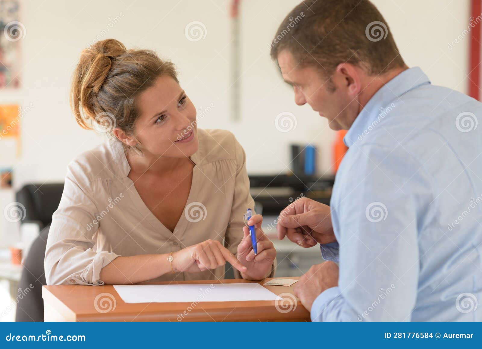 Secretary Helping Male Customer To Complete Paperwork Stock Photo ...