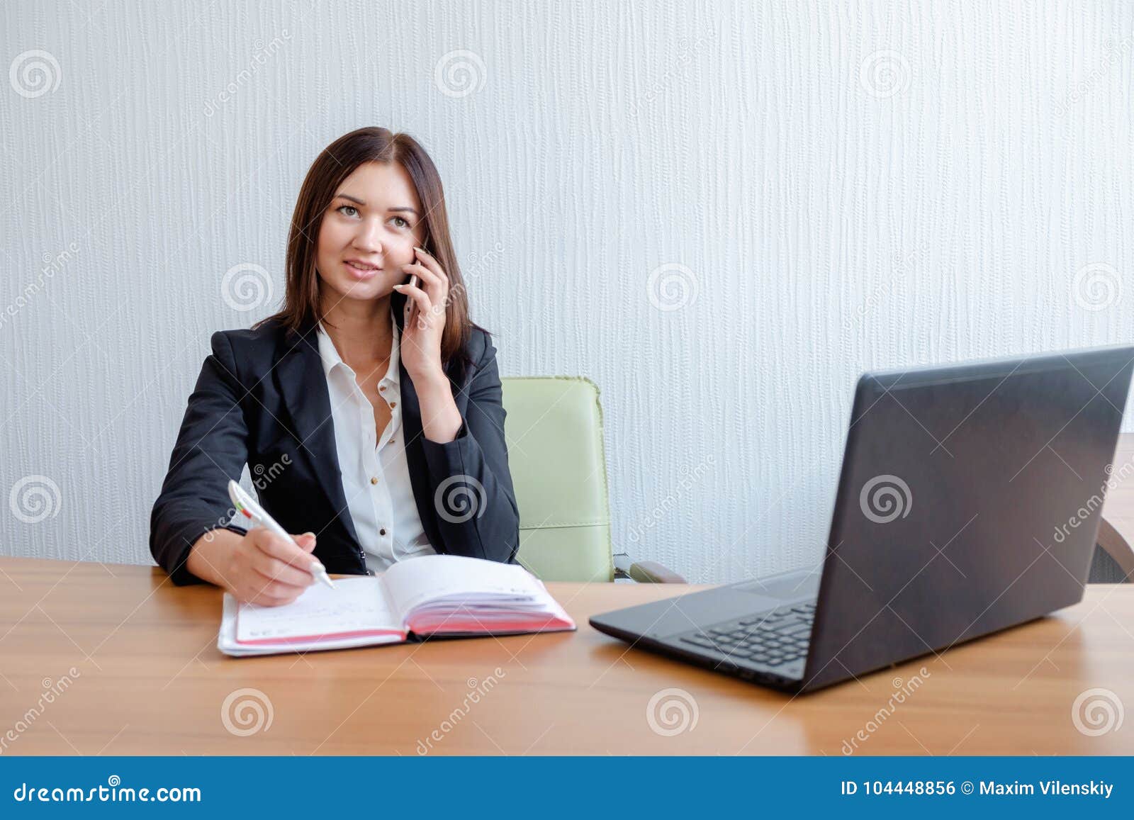 Secretary Talking on Mobile Phone and Writing Notes while Sitting at ...