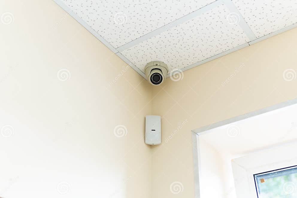Security Camera and Motion Detector Installed on Ceiling in Room. Stock ...