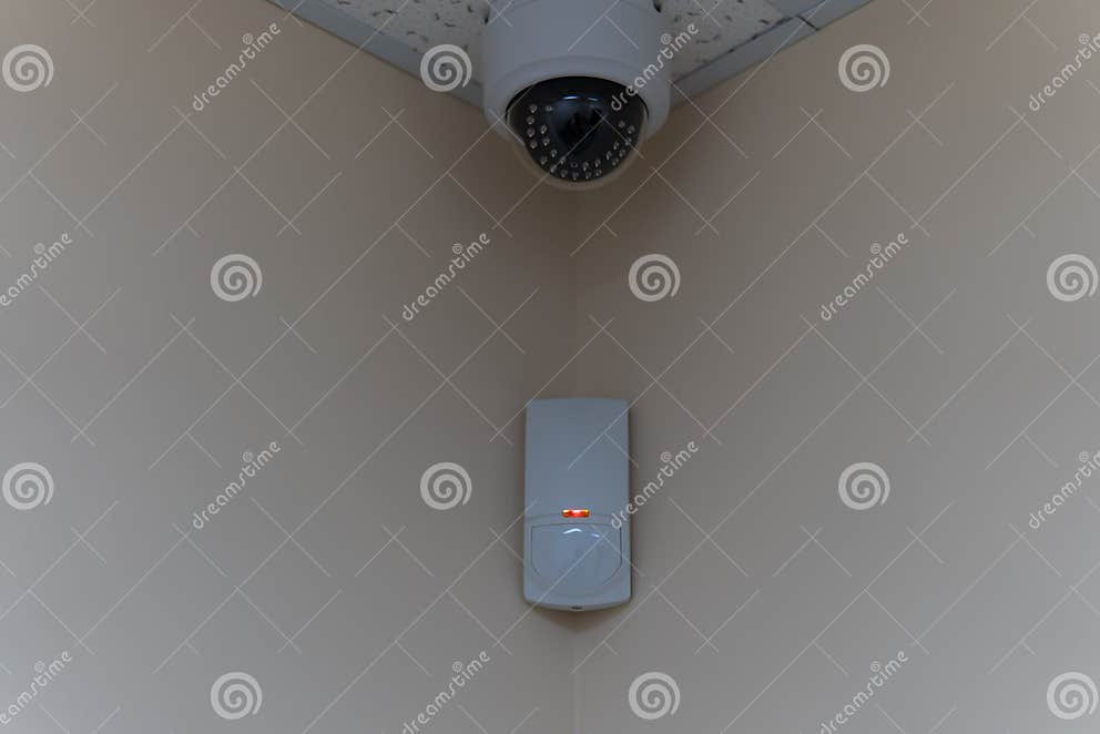 Security Camera and Motion Detector Installed on Ceiling in Room. Stock ...