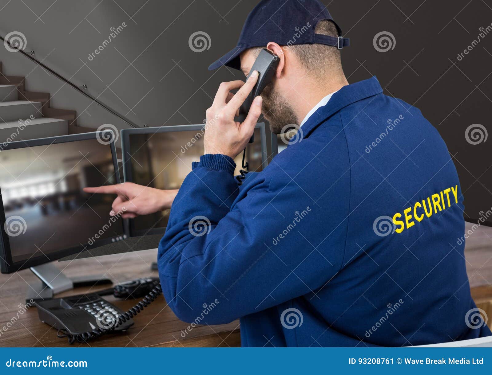 Security Guard in His Office Phoning and Pointing Something in the ...