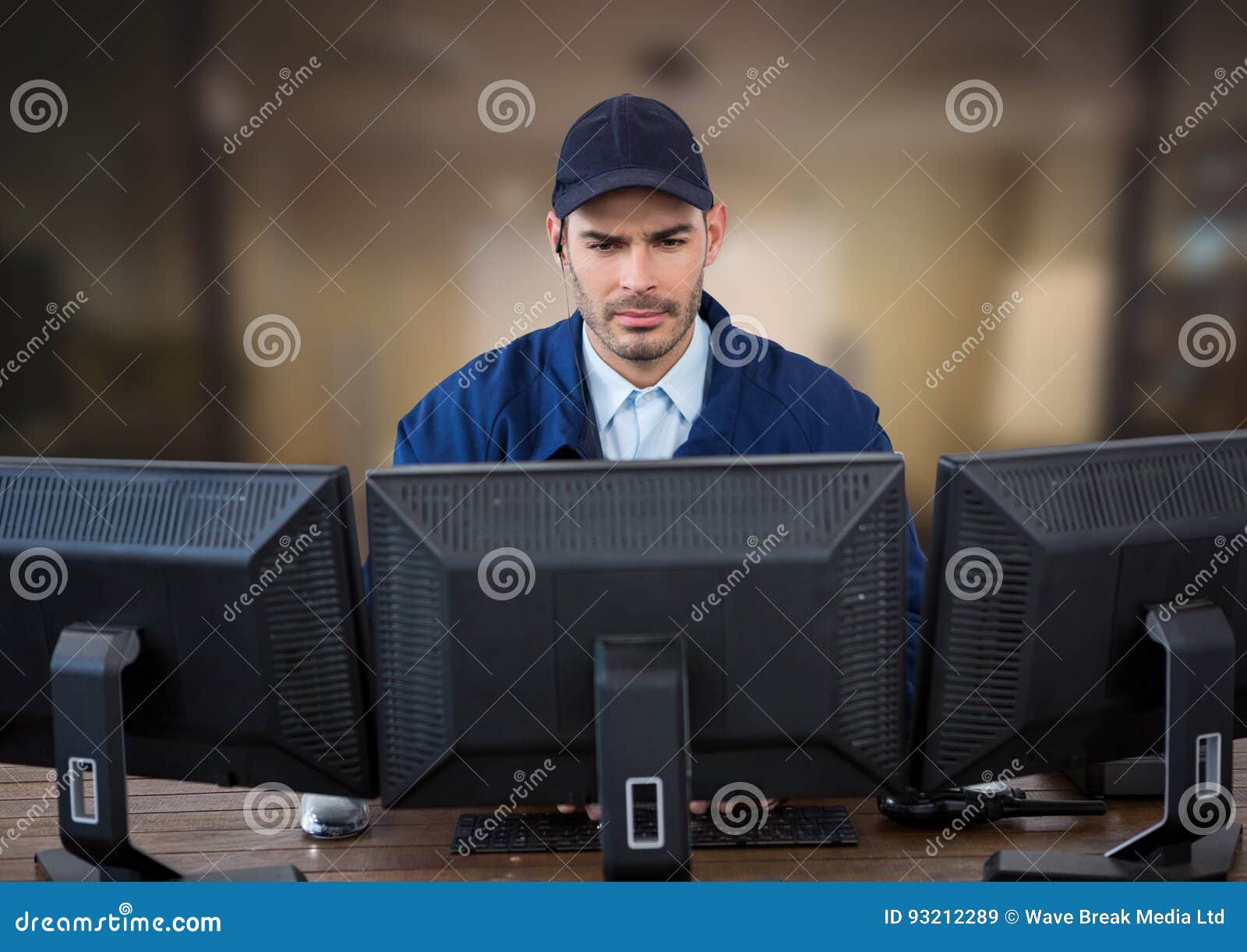 Security Guard Looking The Screens In A Blurred Office Background Stock ...
