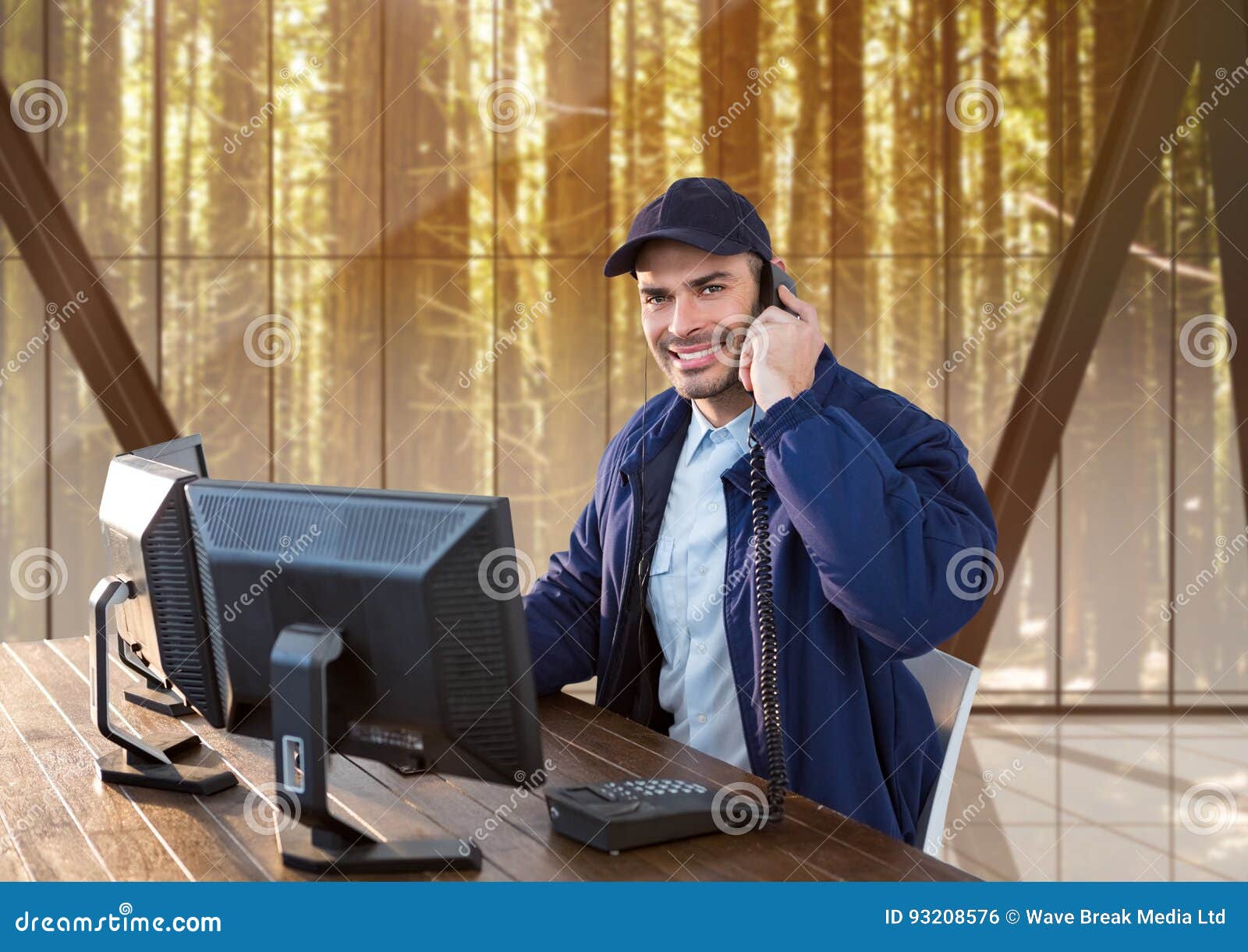 Security Guard Sitting in His Office, is Using Technology, Phoning and ...