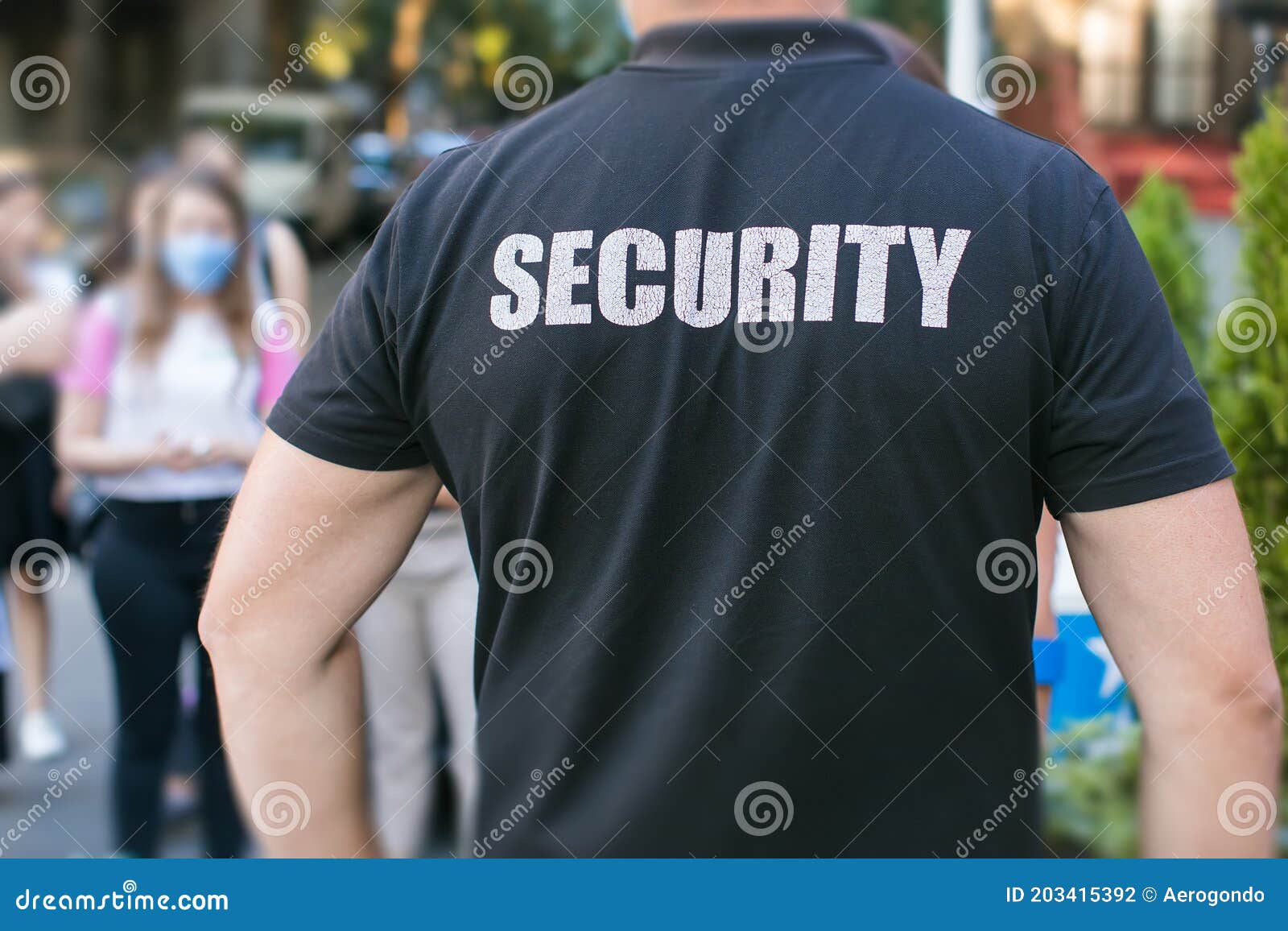 Security Guard Standing in Front of Crowd Wearing Face Masks Stock ...