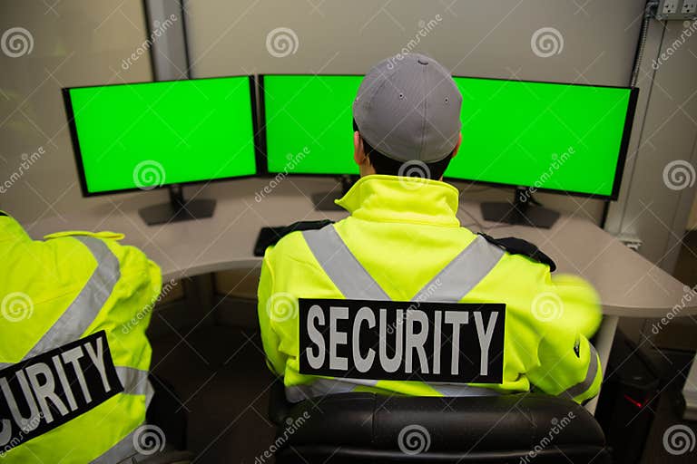Security Officers with a Yellow Jacket Sitting at the Office in Front ...