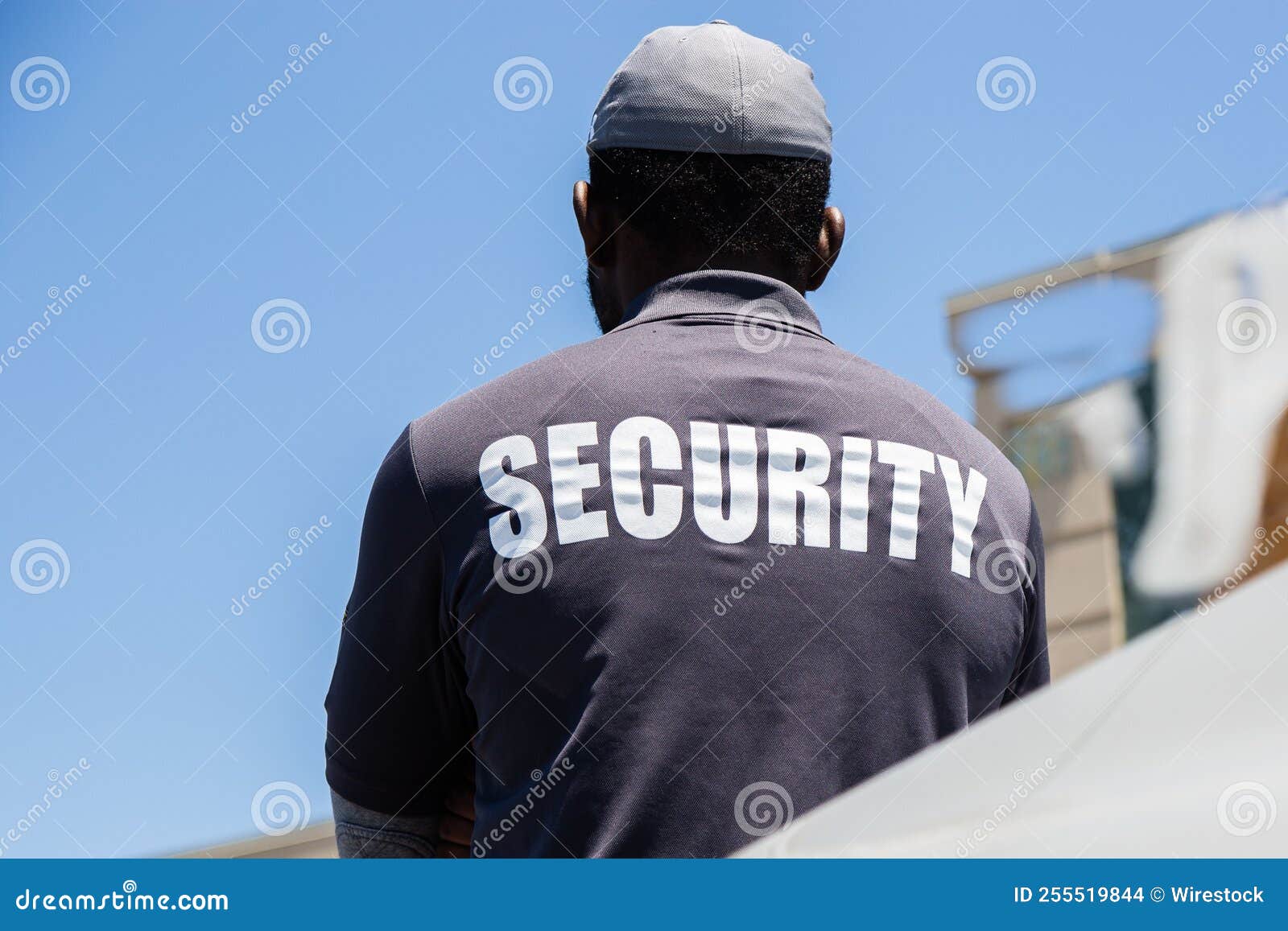 Security Person Standing Outdoors in the Sun, Shot from Back Stock ...