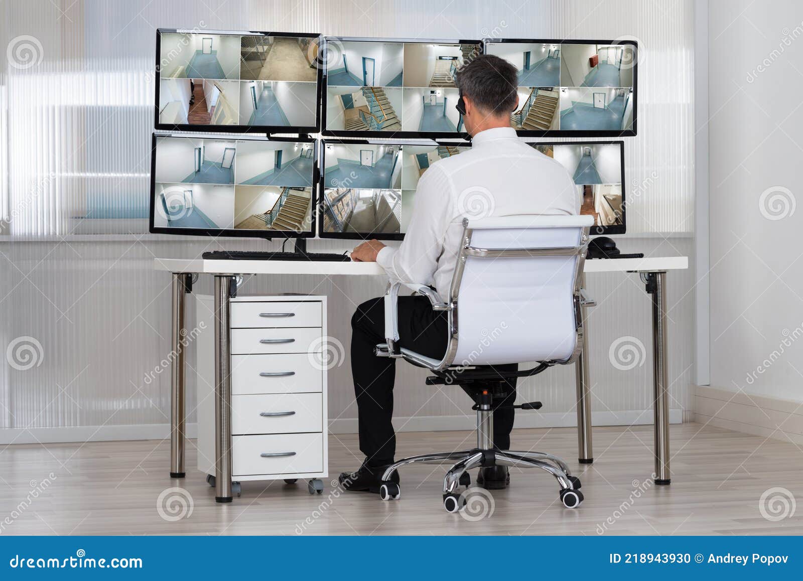 Security System Operator Looking at CCTV Footage at Desk Stock Photo ...