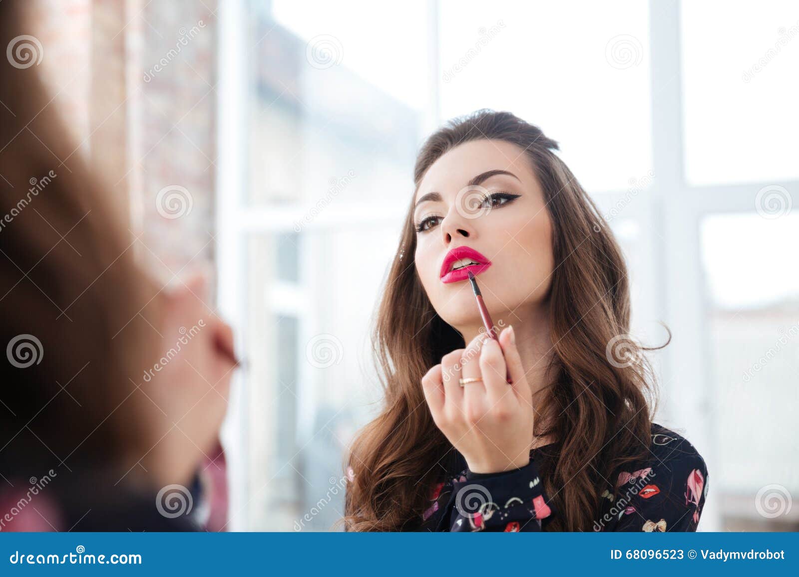 Seductive Woman Applying Red Lipstick To Lips Looking In Mirror Stock