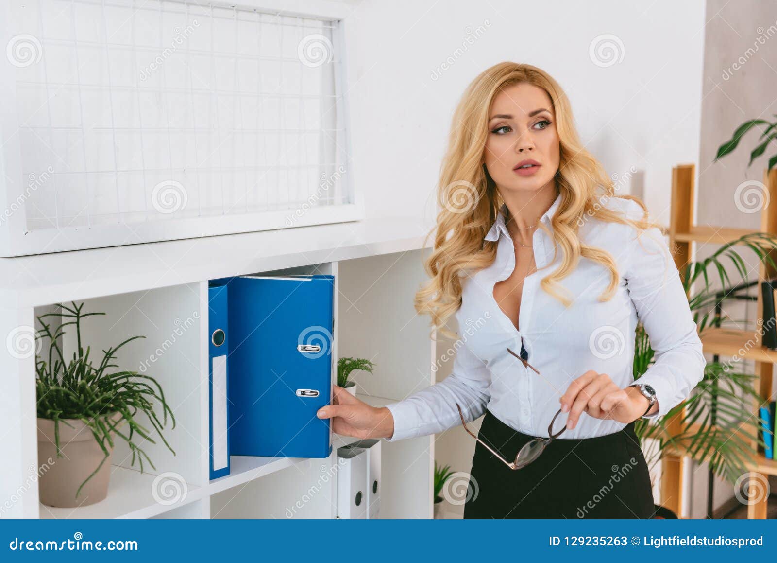 Seductive Woman Taking Folder from Shelf Stock Image - Image of ...